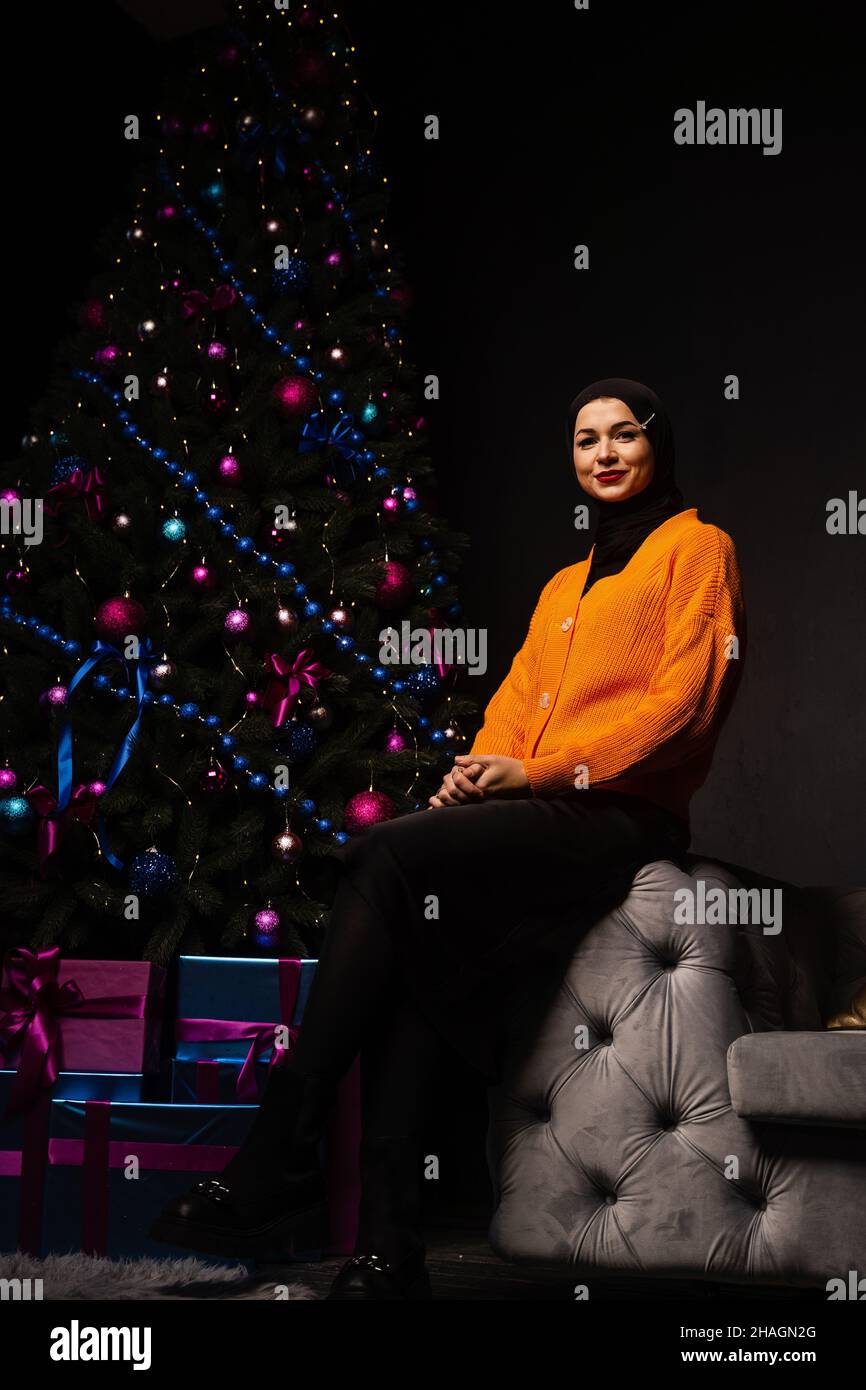 Muslim Christmas celebration. Model weared black hijab is prepearing ...
