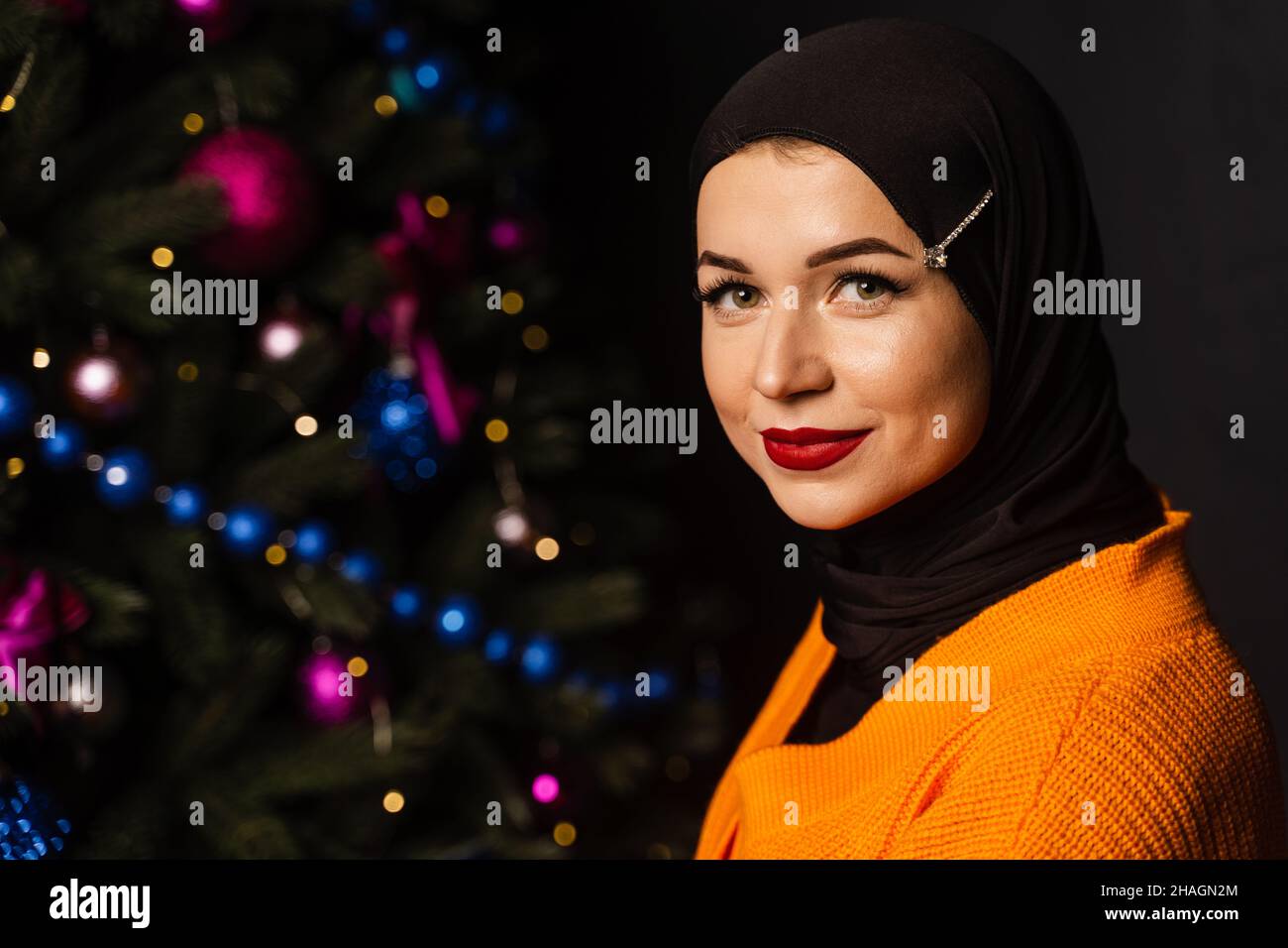 Muslim Christmas celebration. Model weared black hijab is prepearing ...