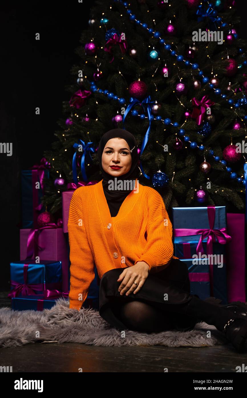 Muslim Christmas celebration. Model weared black hijab is prepearing ...