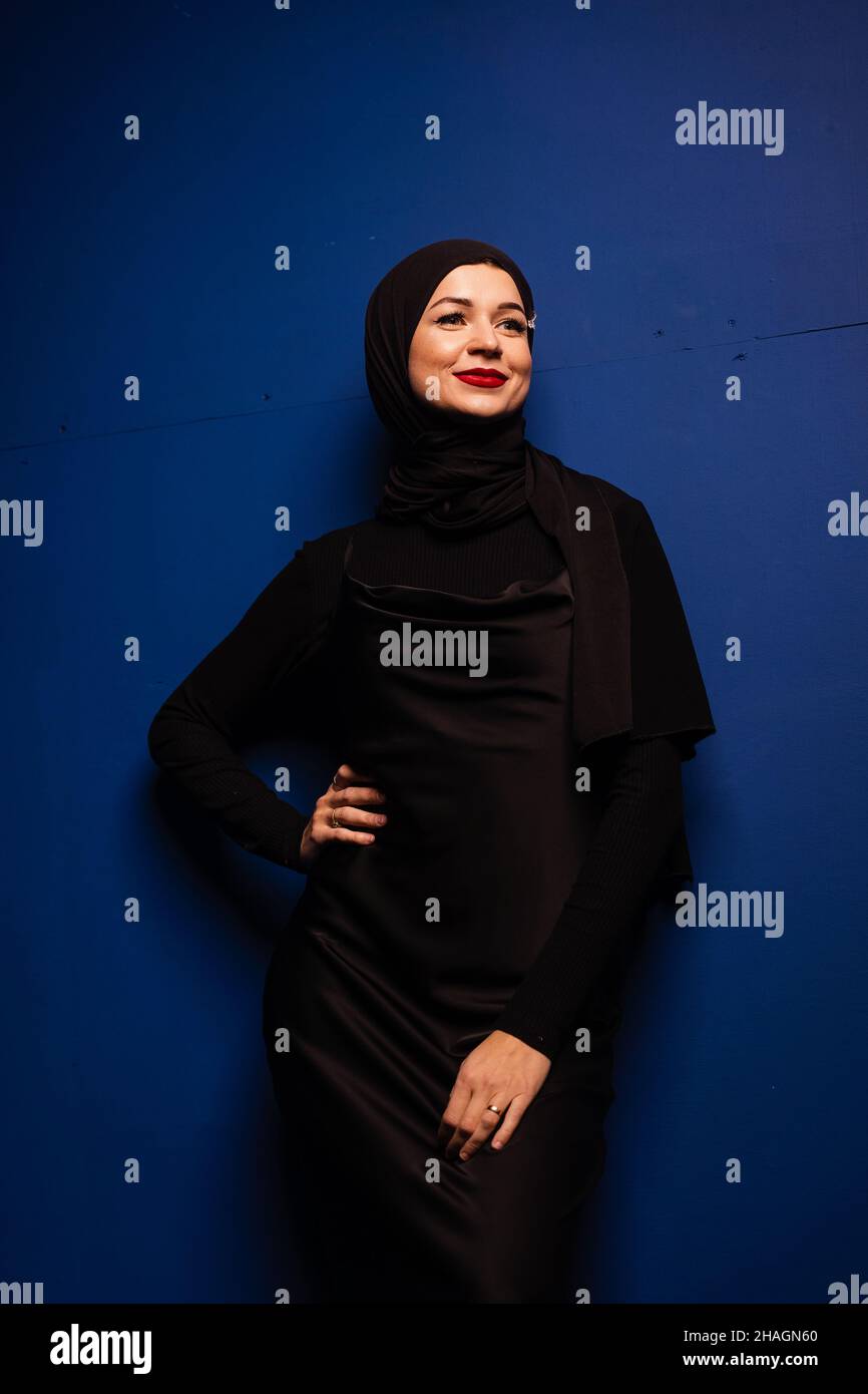 Fashion muslim model in black hijab is posing on blue background in ...