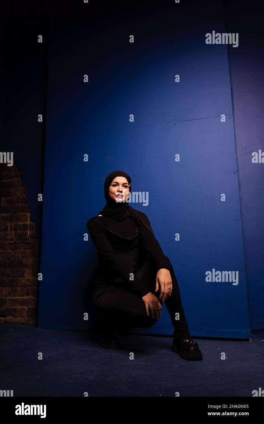 Fashion muslim model in black hijab is posing on blue background in ...
