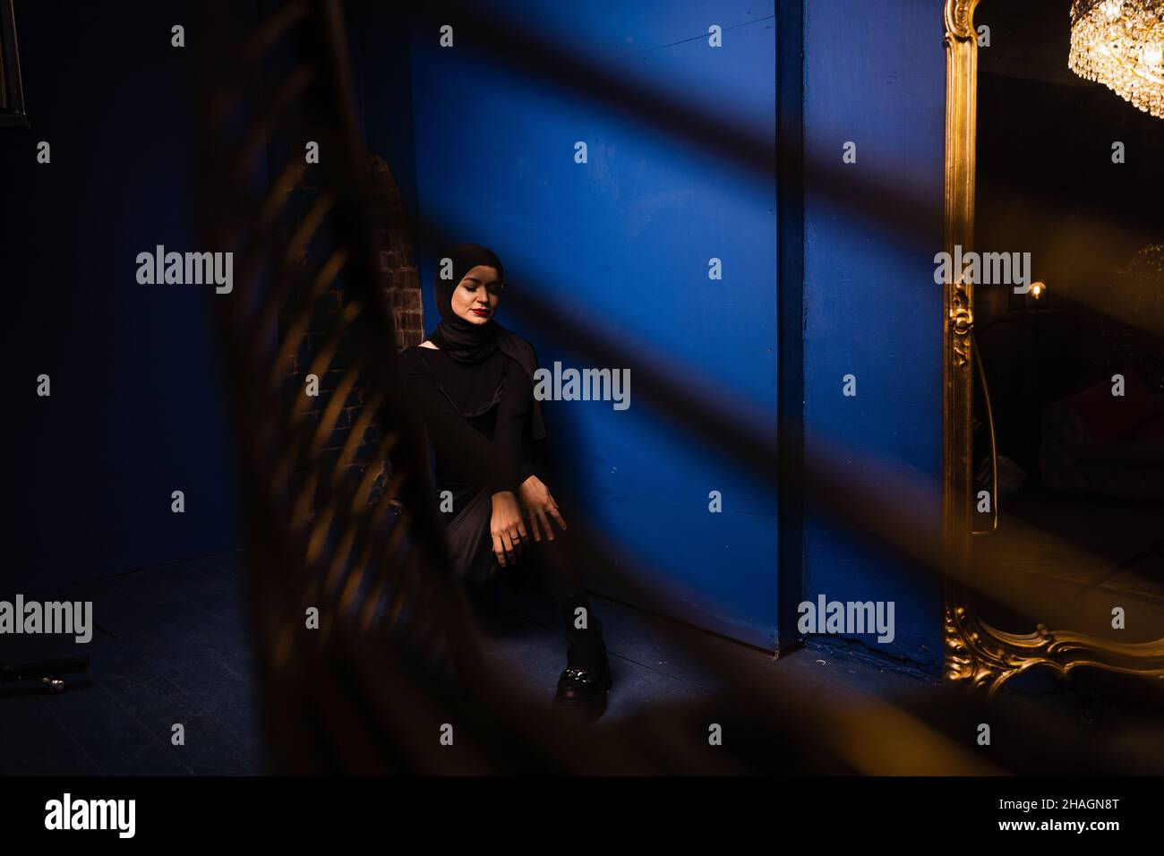 Fashion muslim model in black hijab is posing on blue background in ...