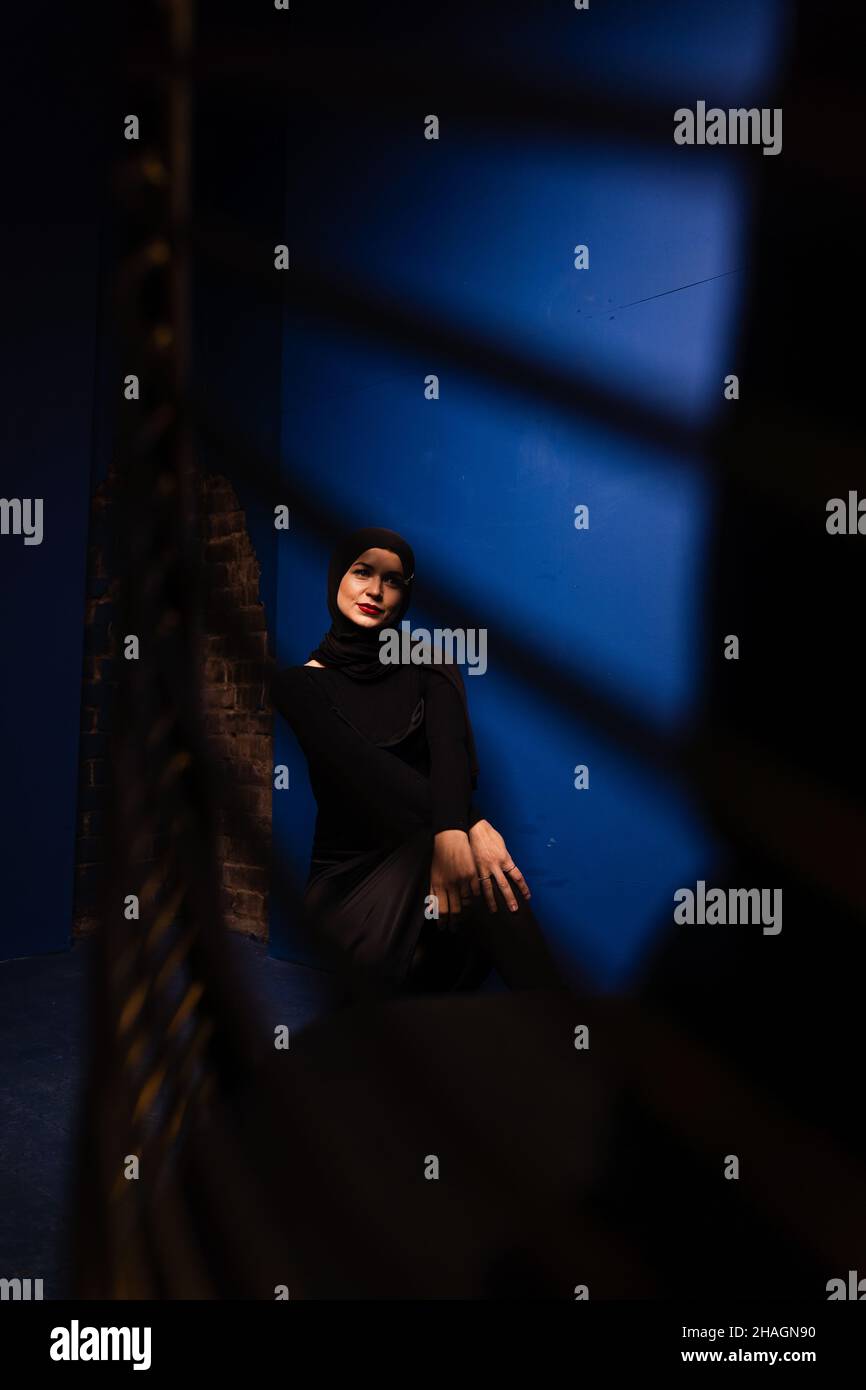 Fashion muslim model in black hijab is posing on blue background in ...