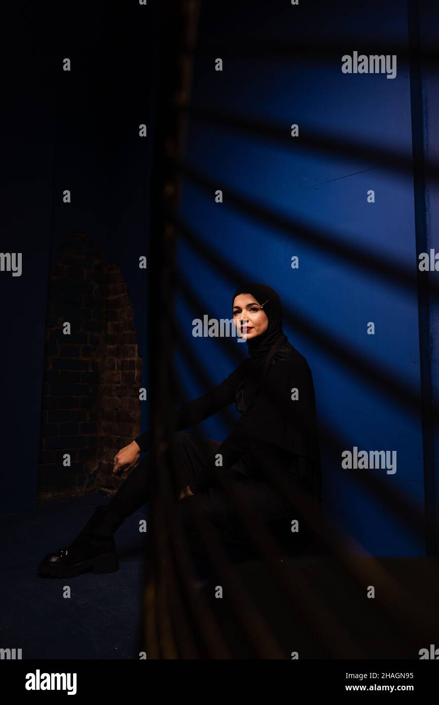 Fashion muslim model in black hijab is posing on blue background in ...