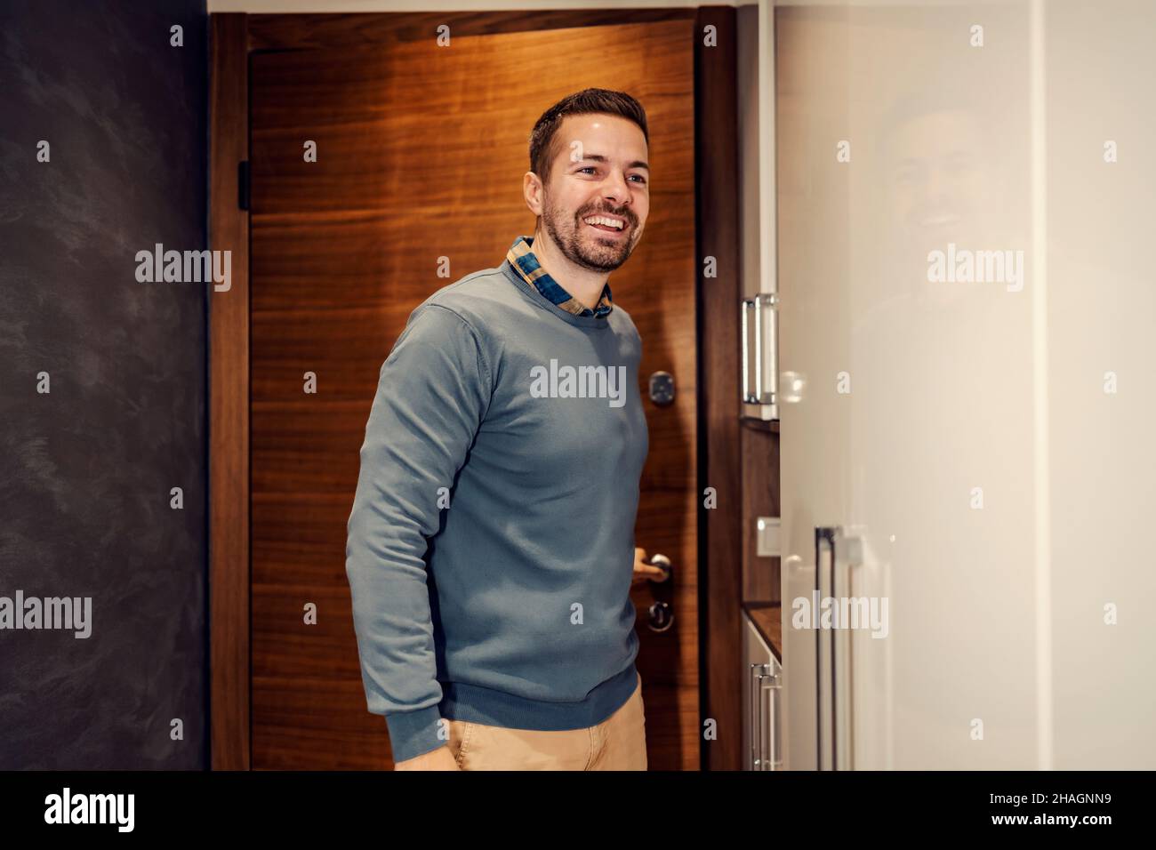 Family of friends visits. A happy visitor enters the host's home and ...