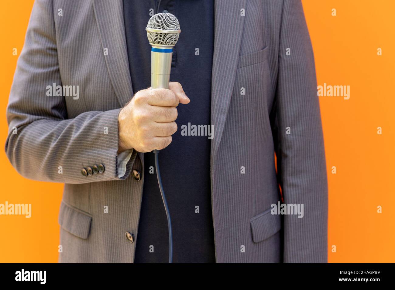 Reporter holding microphone during media report or interview Stock Photo - Alamy