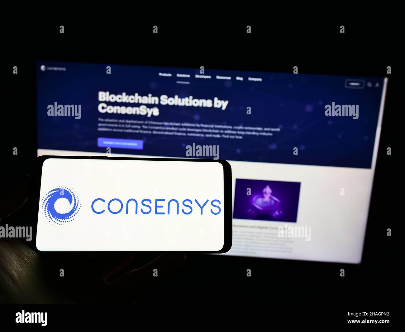 Person holding mobile phone with logo of American blockchain software ...