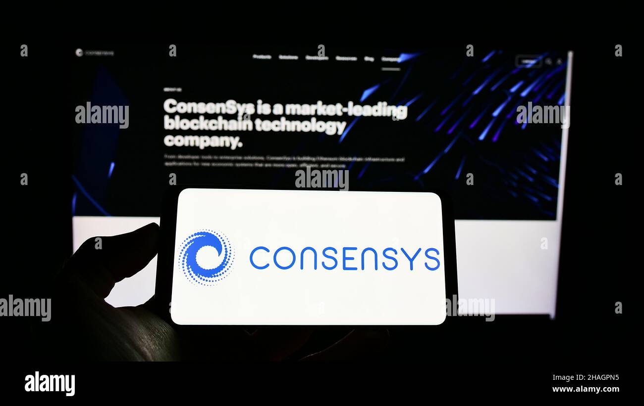 Person holding cellphone with logo of US blockchain software company ...