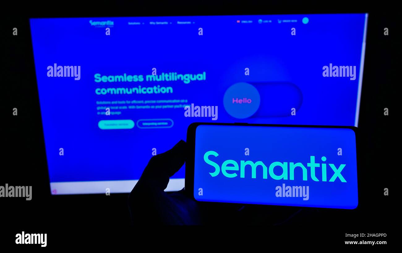 Person holding smartphone with logo of Swedish language company ...