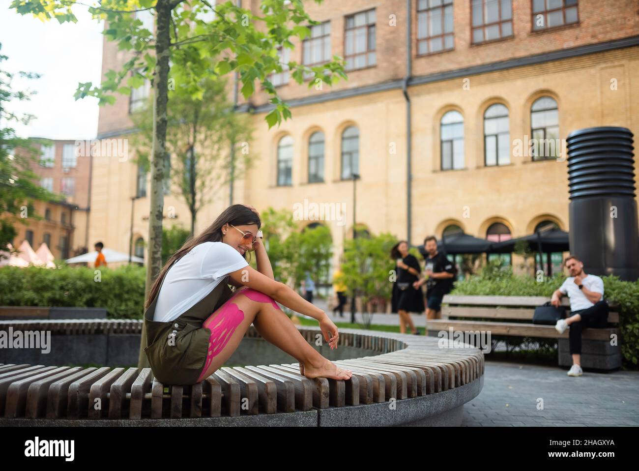Young woman on a park bench posing at the camera Stock Photo - Alamy