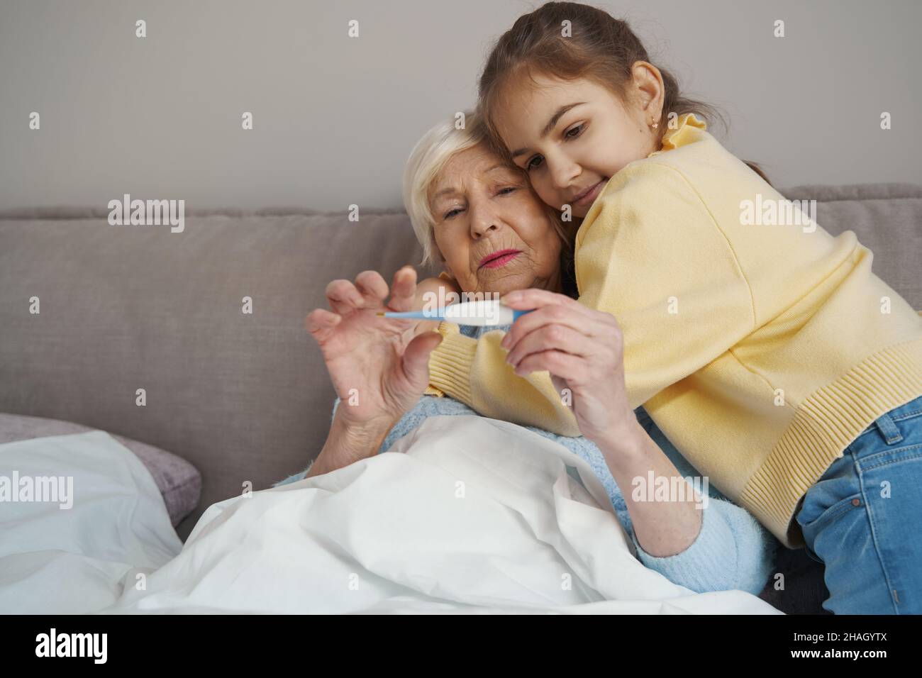 Caring granddaughter hugging her grandma and wishing soon recovery ...