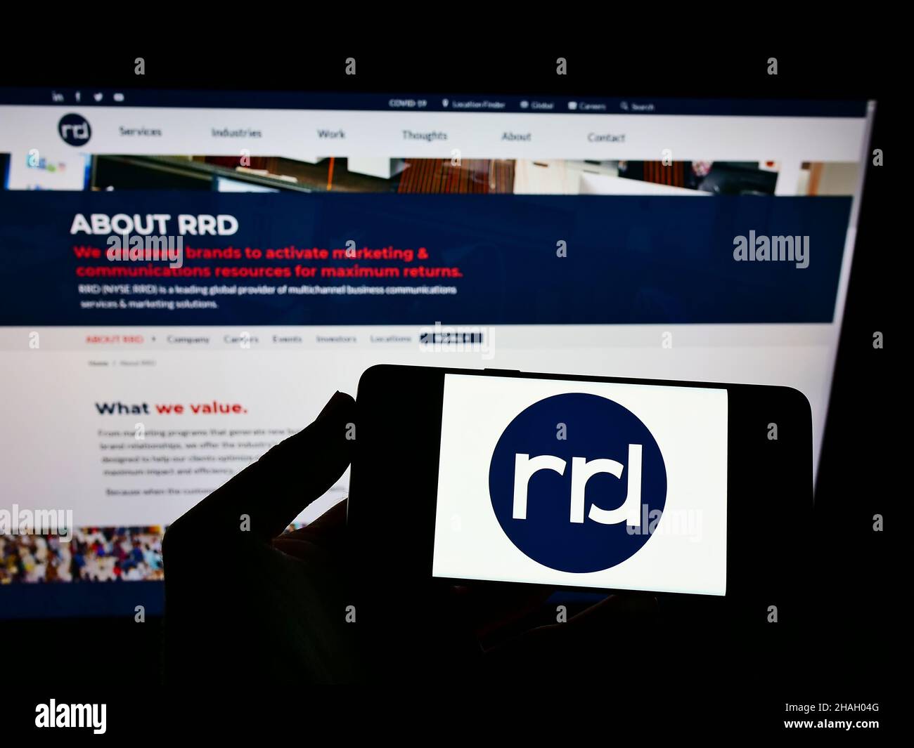 Person holding cellphone with logo of US business RR Donnelley and Sons ...