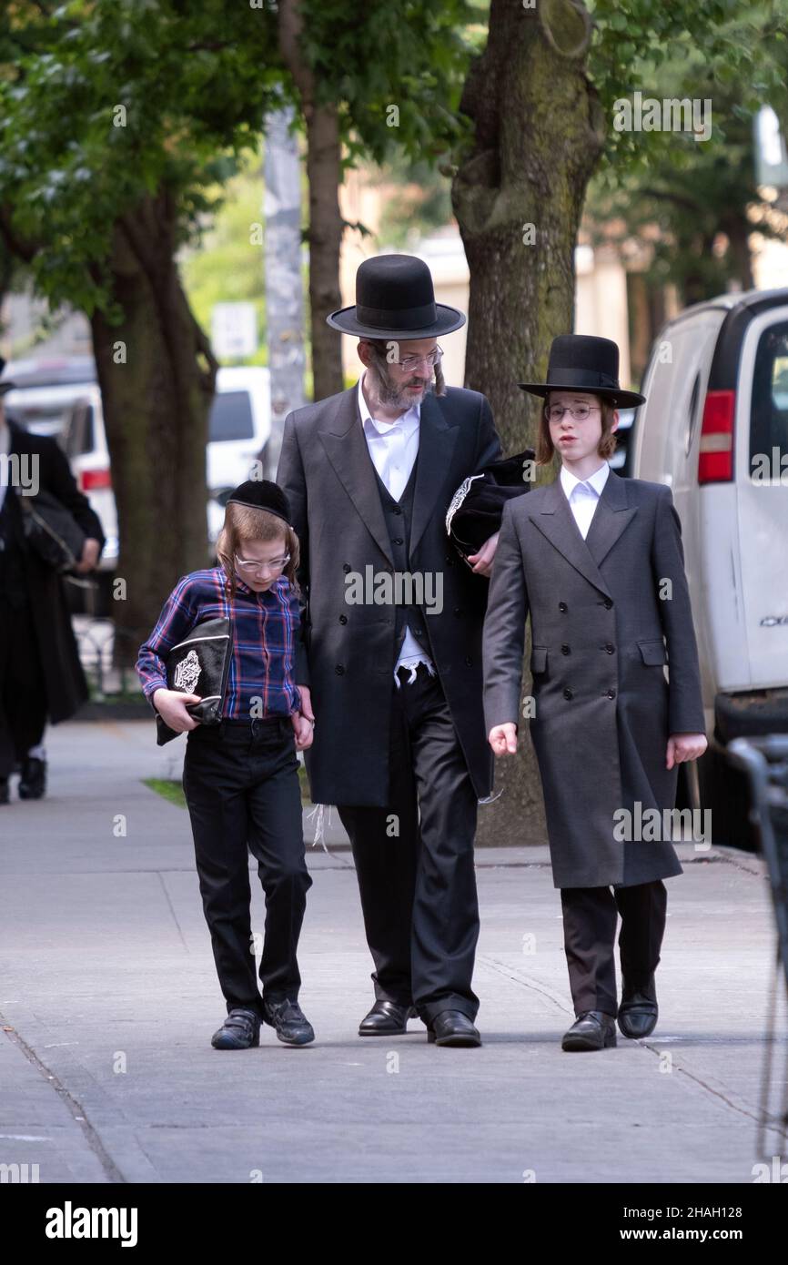 An orthodox Jewish father and son return from synagogue morning ...