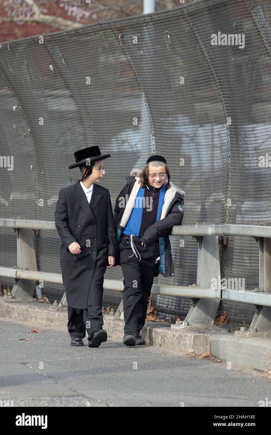 FRIENDS. Orthodox jewish boys with long curly peyot cross a bridge over ...