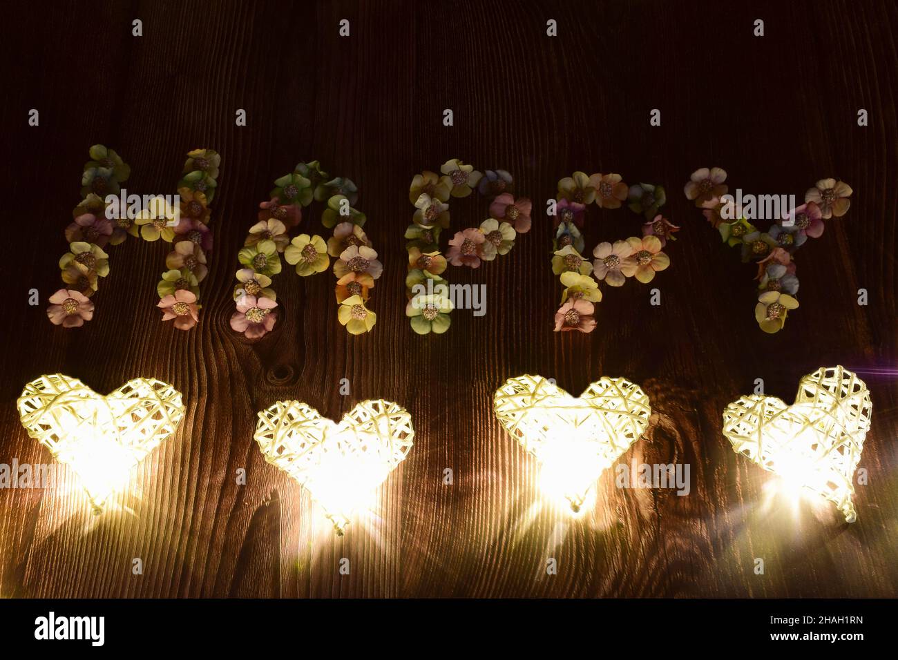 On a wooden background, the word HAPPY is spelled out in large letters ...