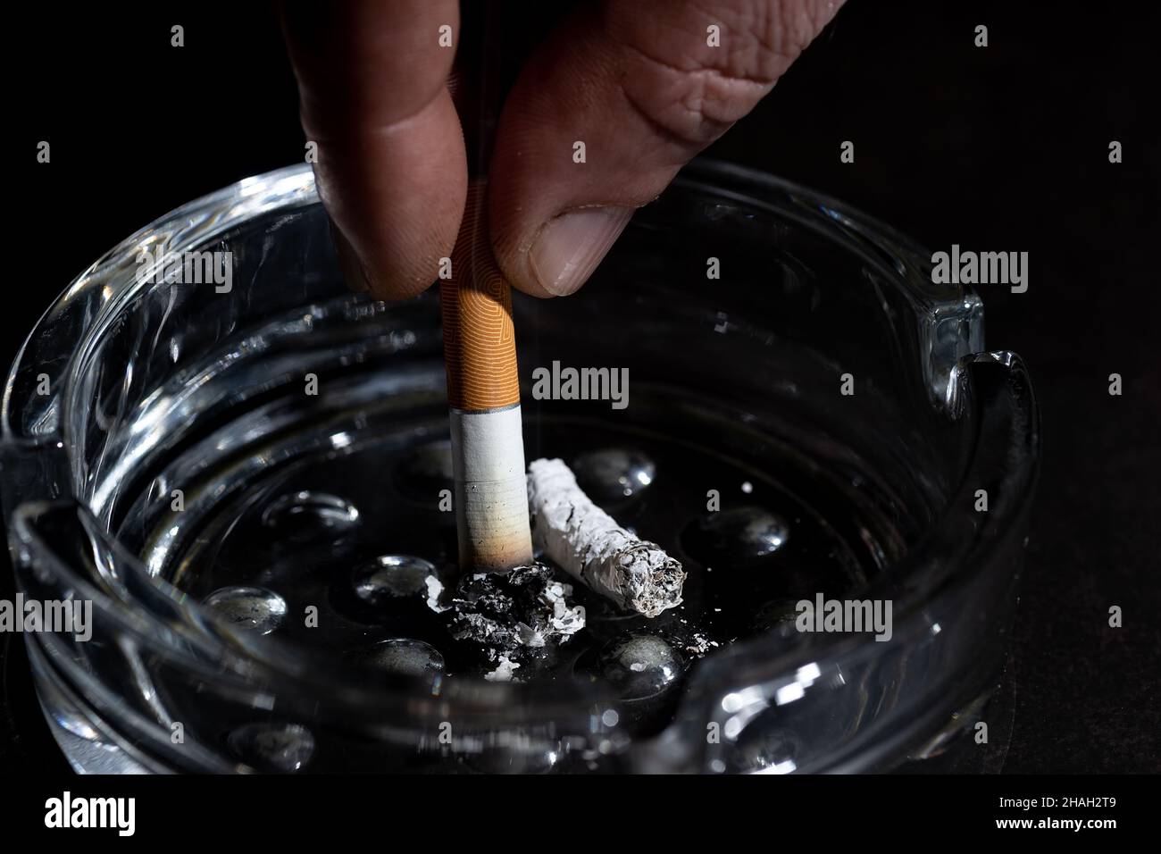 Close up burning cigarette with beautiful wisp of smoke in ashtray with ...