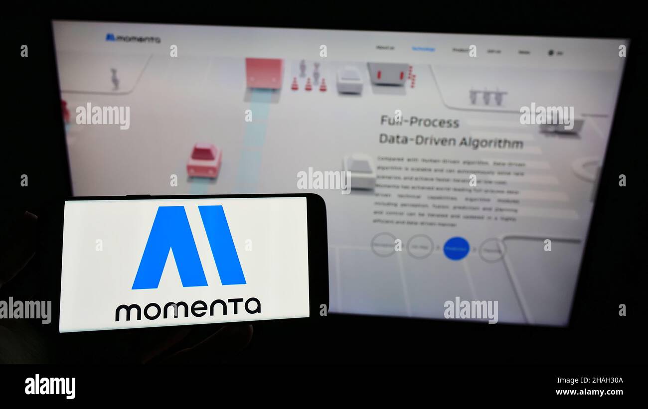 Person holding smartphone with logo of Chinese autonomous driving ...