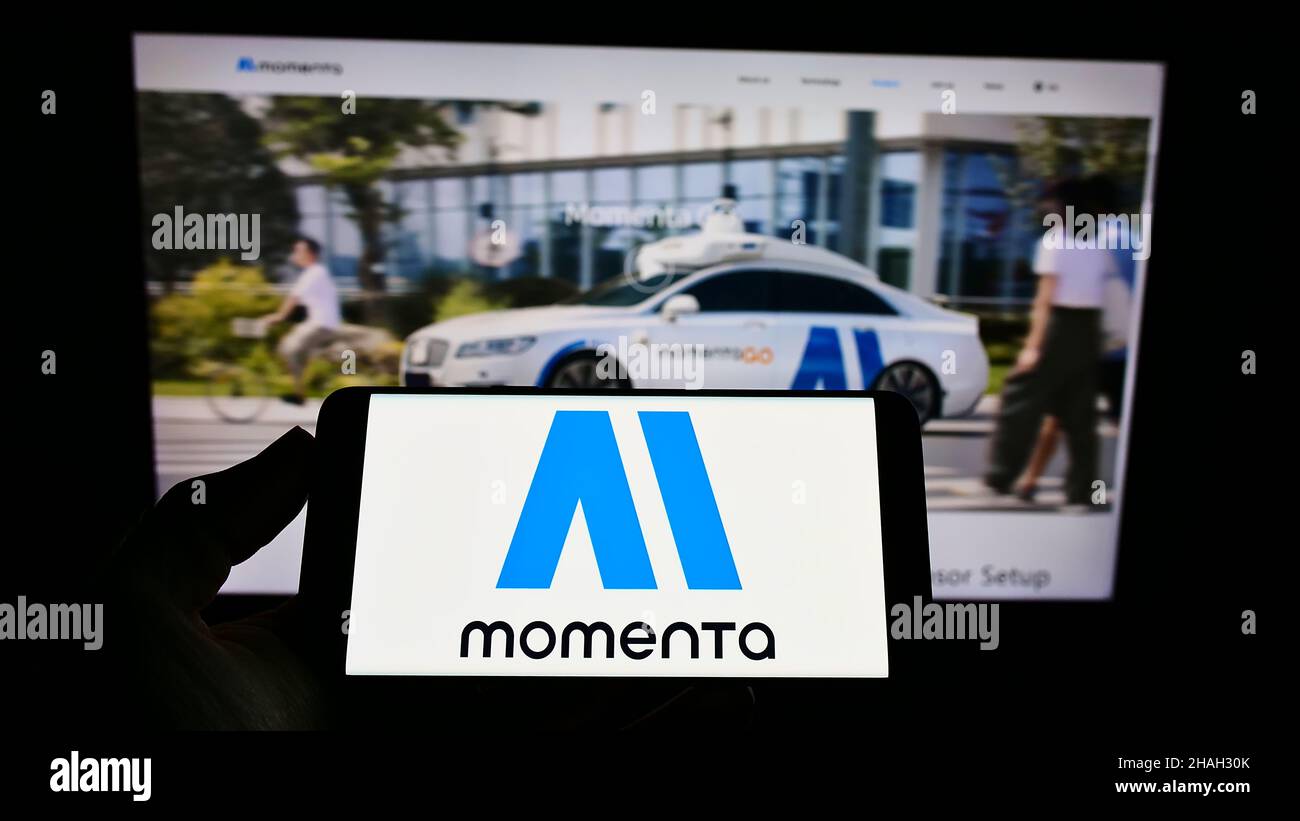 Person holding mobile phone with logo of Chinese autonomous driving ...