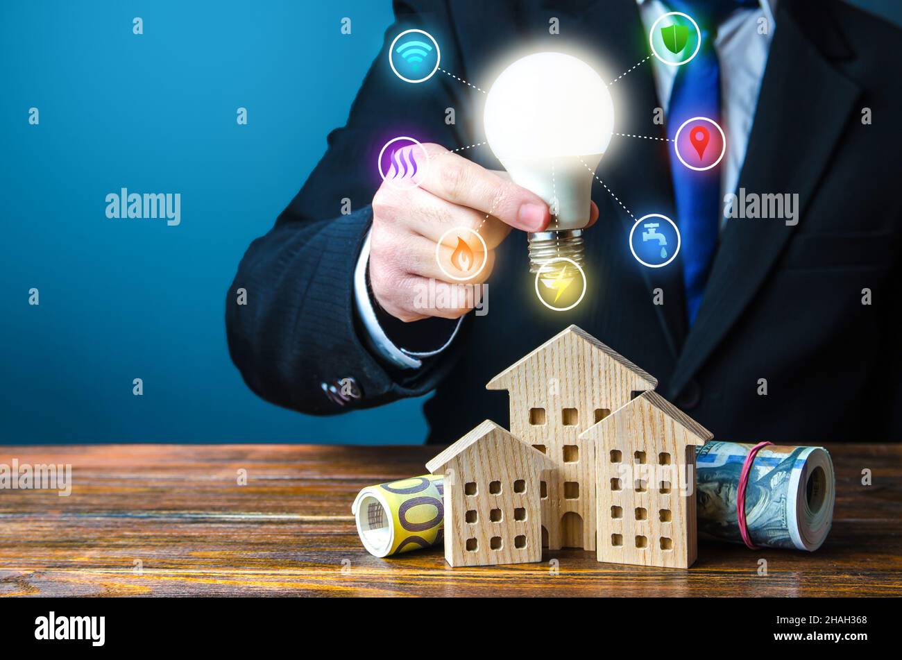 Man holding a light bulb over the house. Electricity, water, gas ...