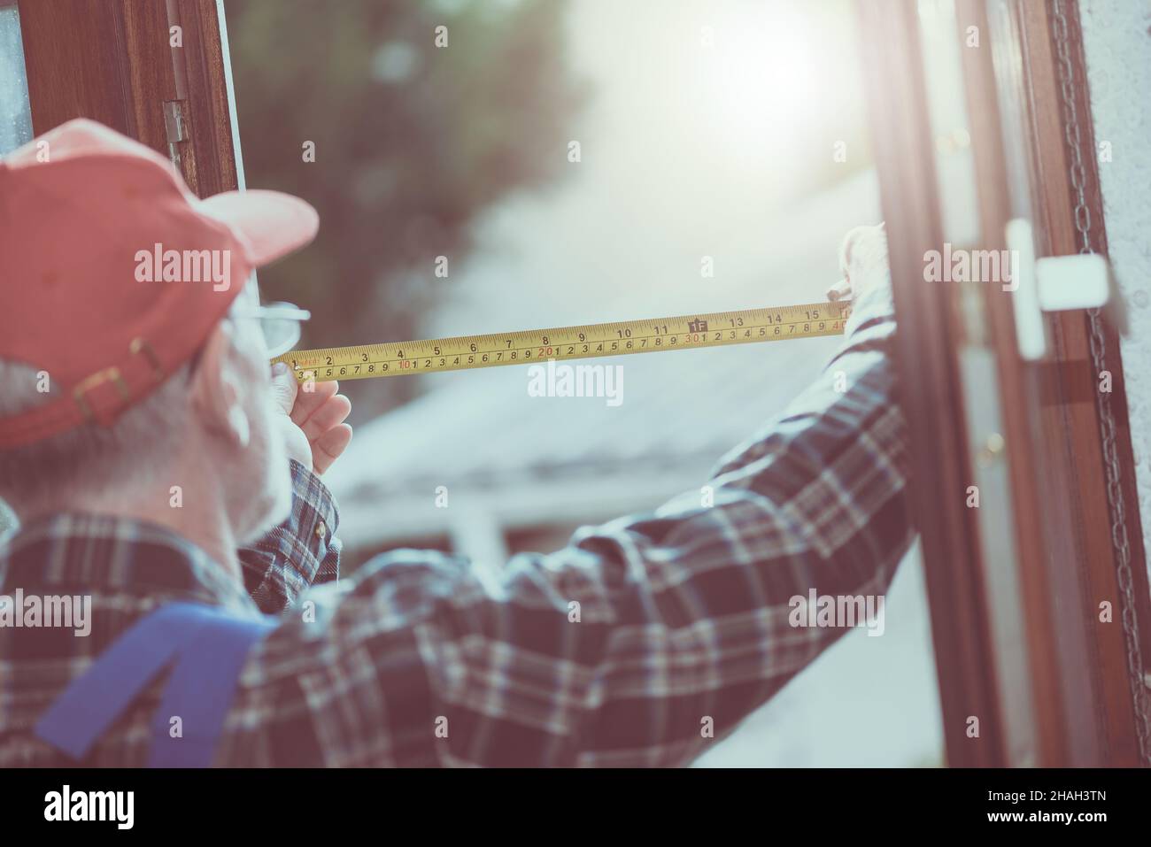 Senior repairman taking measures with tape measure Stock Photo - Alamy