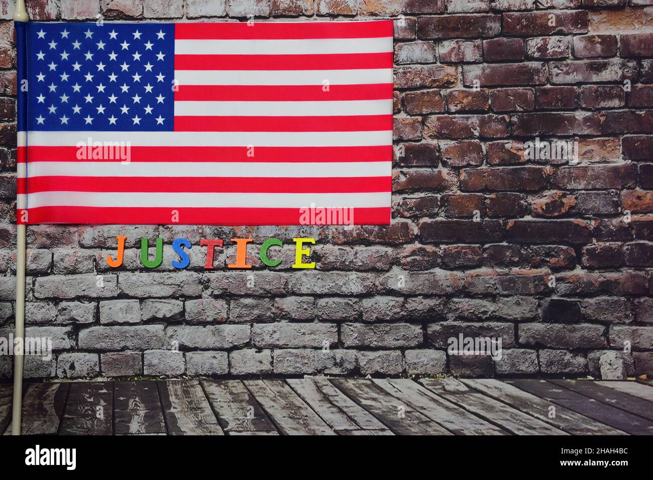 The word JUSTICE is lined with multicolored letters under the US flag ...
