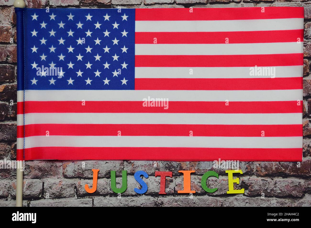 The word JUSTICE is lined with multicolored letters under the USA flag ...
