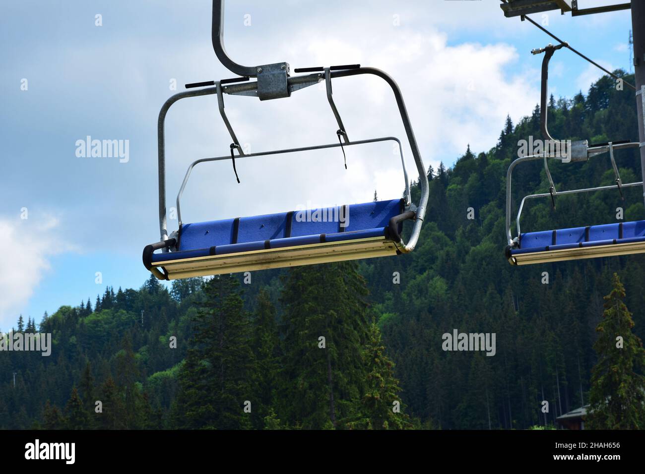Empty two benches of the ski lift in blue, without people in motion ...