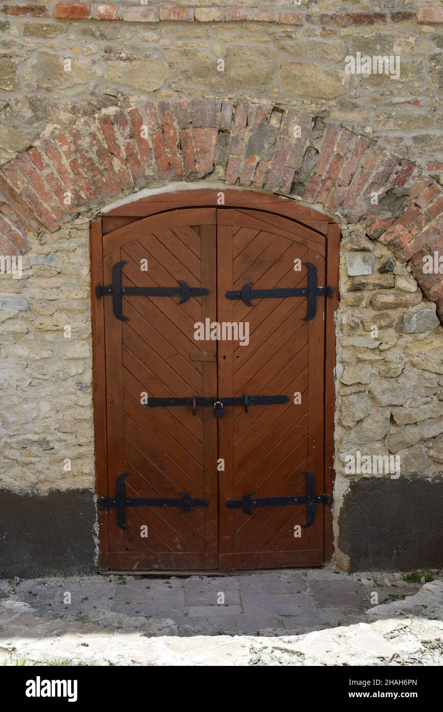 Wooden gates of an old medieval castle or fortress, covered with strips ...