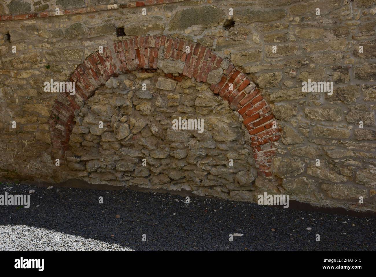 In the wall of a medieval ancient masonry building there is an arched ...