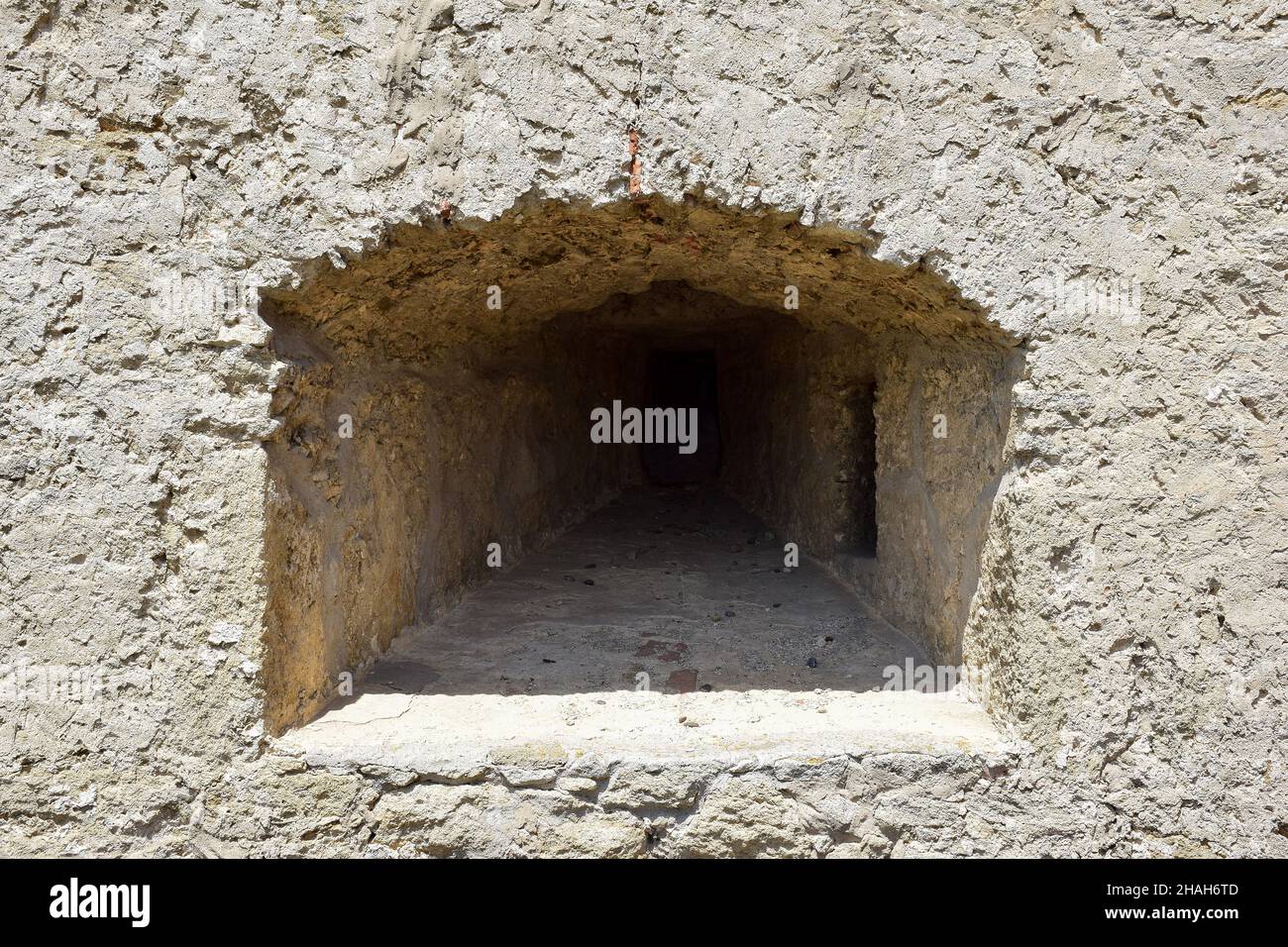 An embrasure for shooting in the thick wall of an old fortress or ...