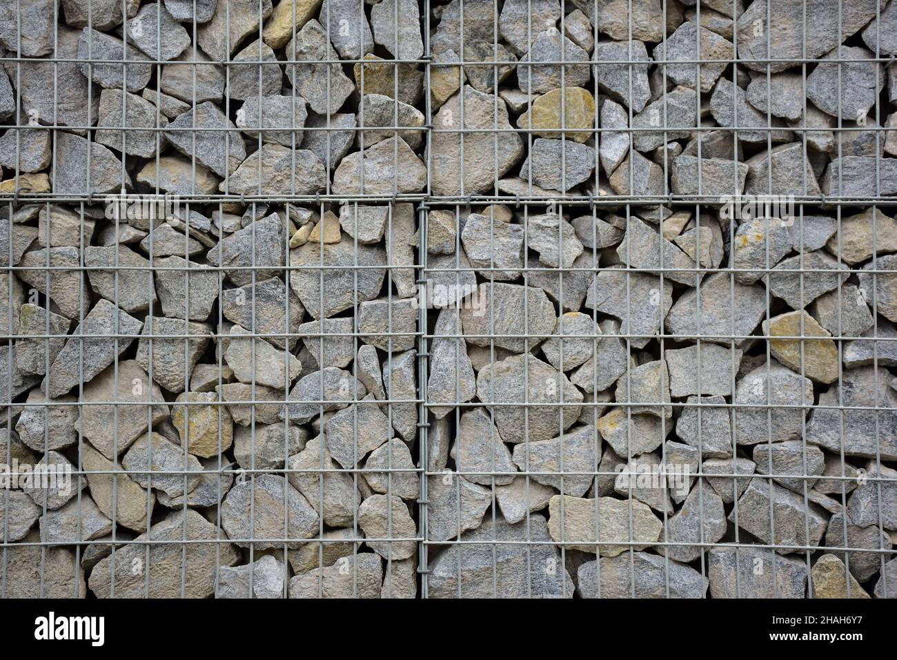 A large fence of many stone cobblestones supported by a stone trellis ...