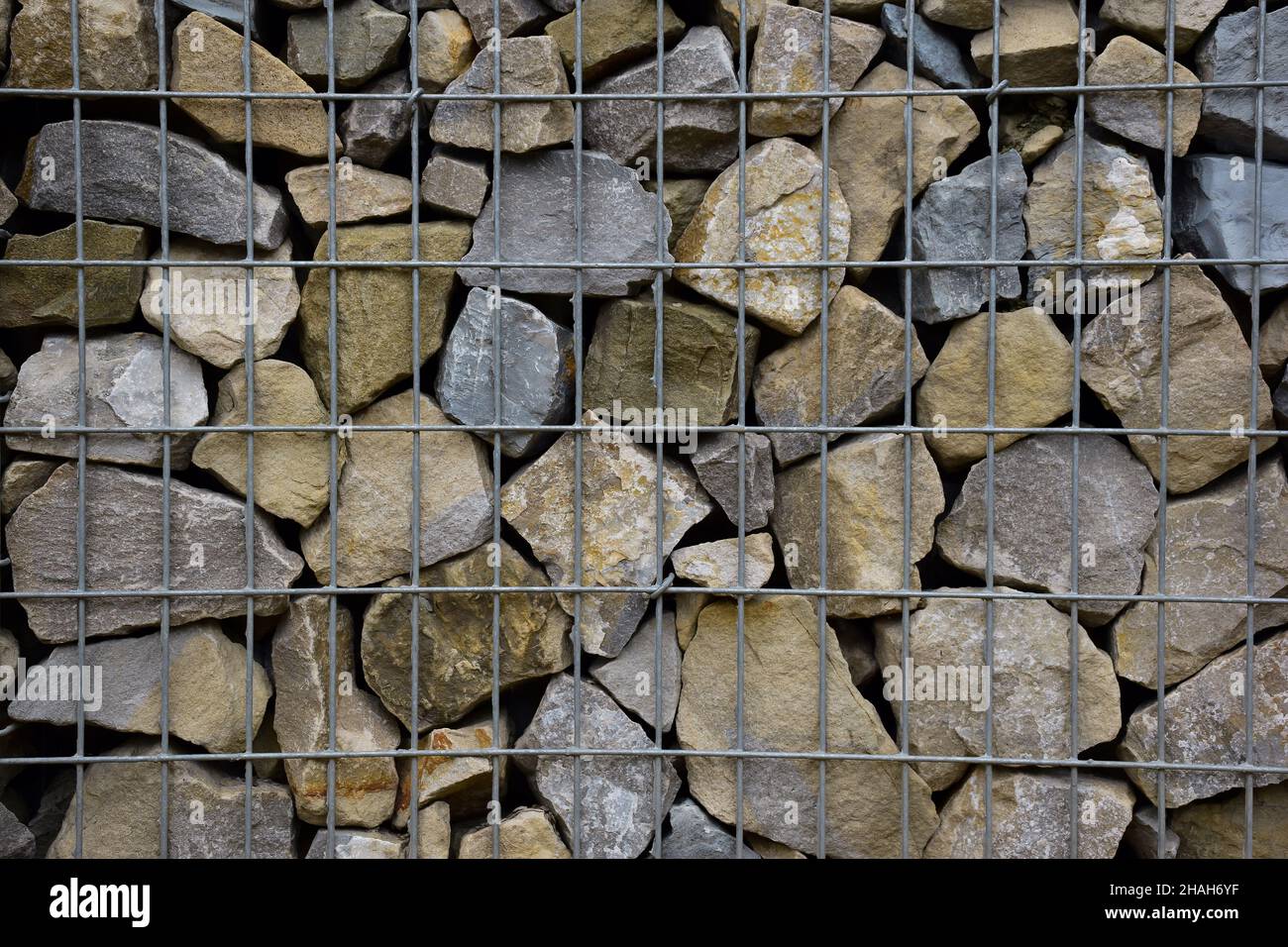 A large fence of many stone cobblestones supported by a stone trellis ...