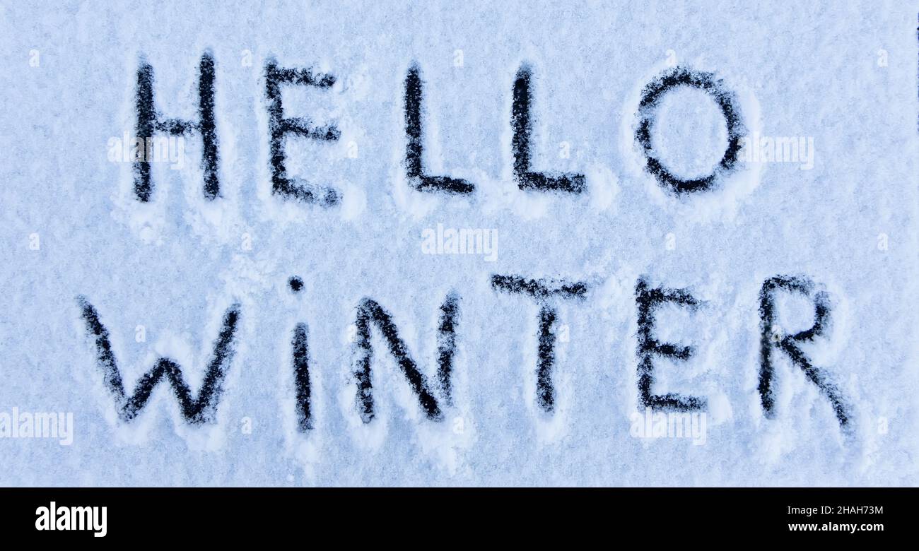 Hello Winter words written on the surface of a snow field. Start of new ...