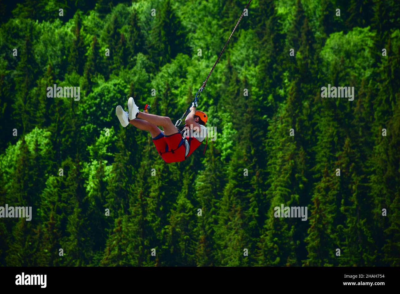 A young man in a helmet jumped from bungee jumping and now hangs on a ...
