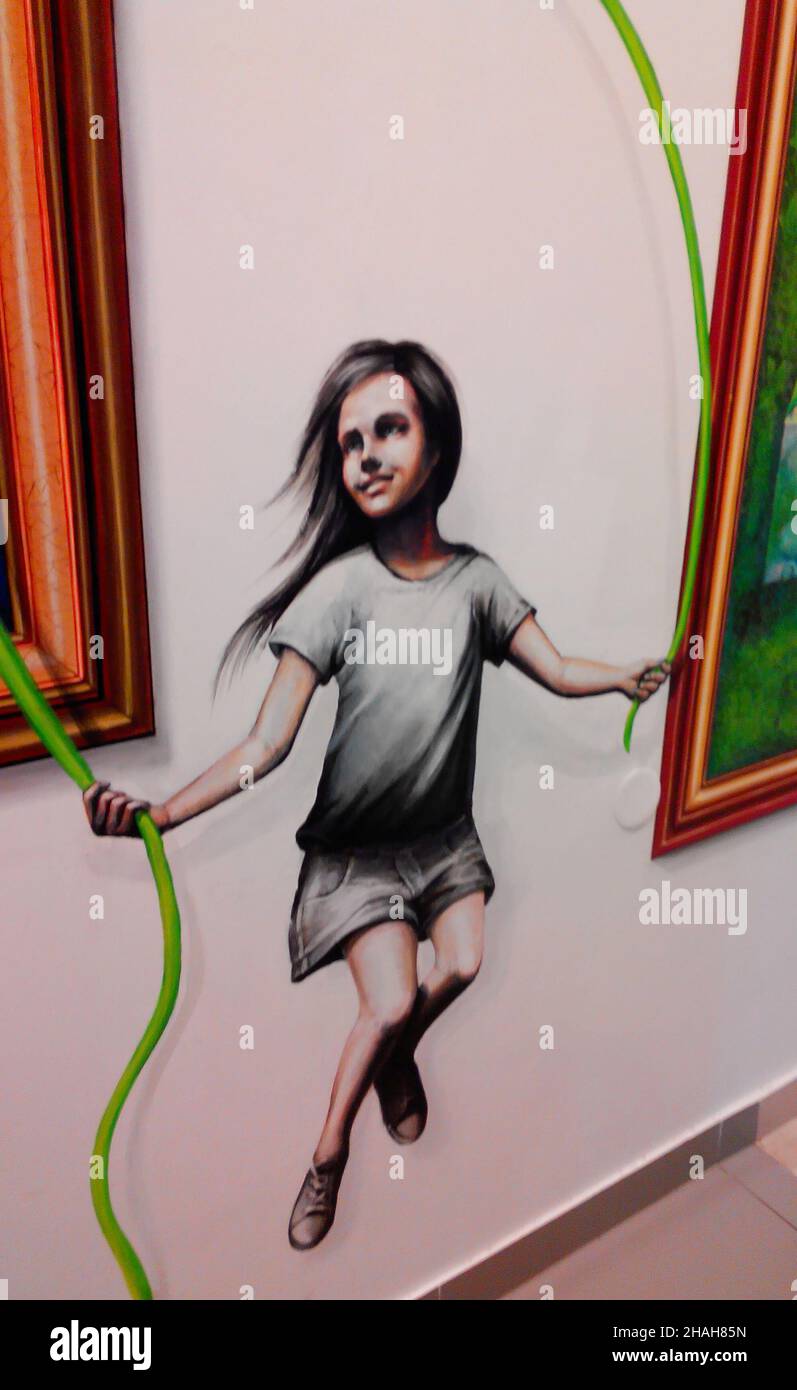 Drawn 3D figure of a girl jumping on a rope on the wall Stock Photo - Alamy