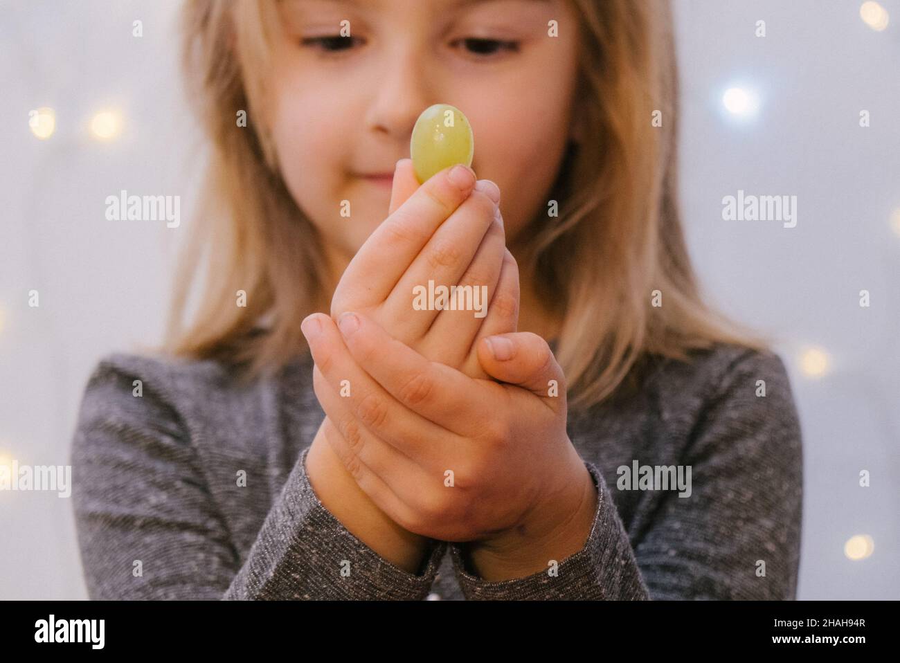 Lttle girl Celebrating New Year eating de twelve grapes. Spanish ...
