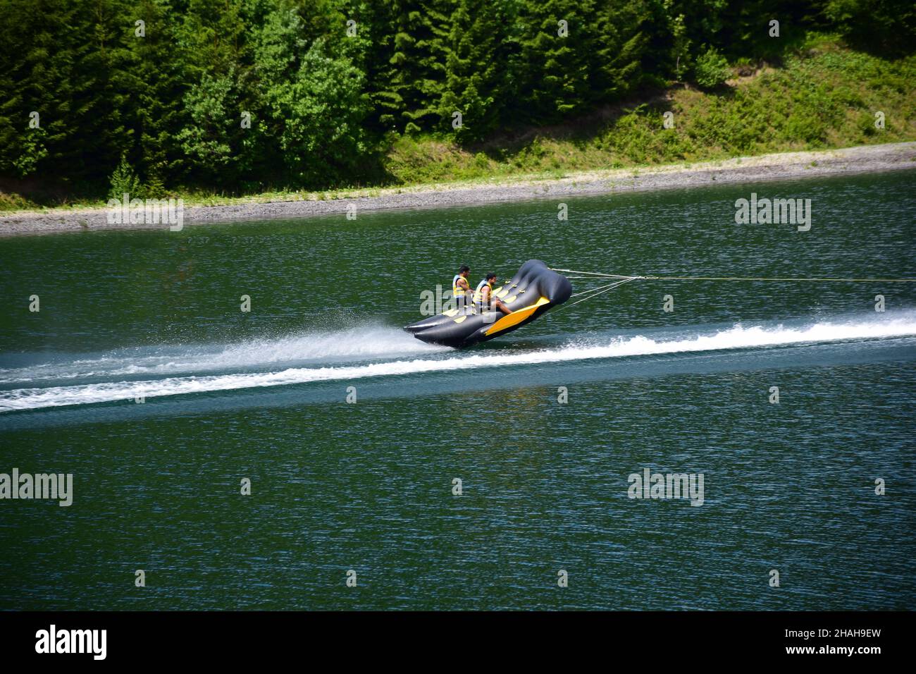 An inflatable sports raft with two men in life jackets quickly floats ...