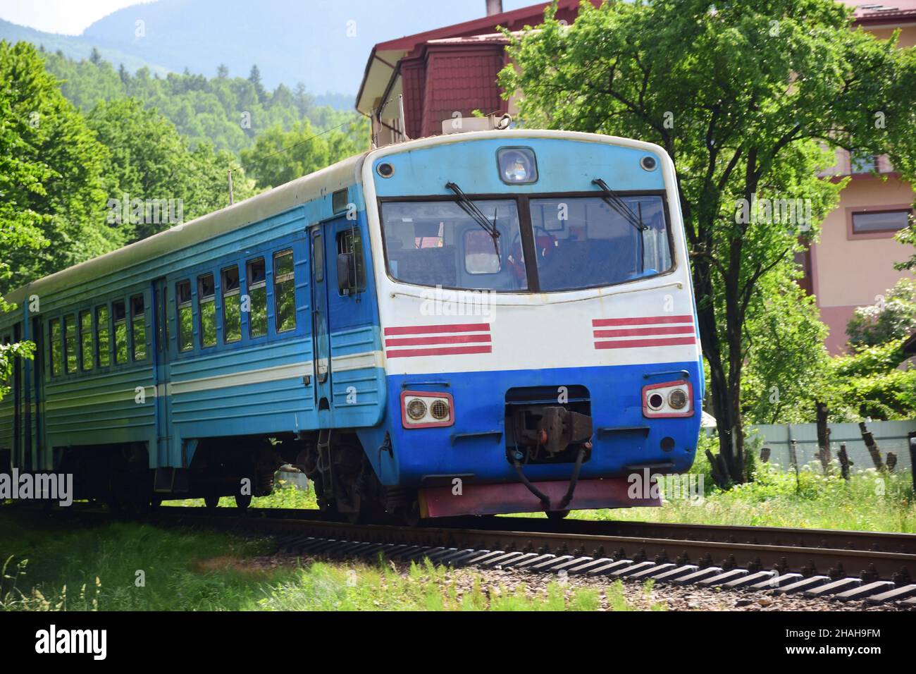 An old-fashioned electric train is approaching the railway station of a ...