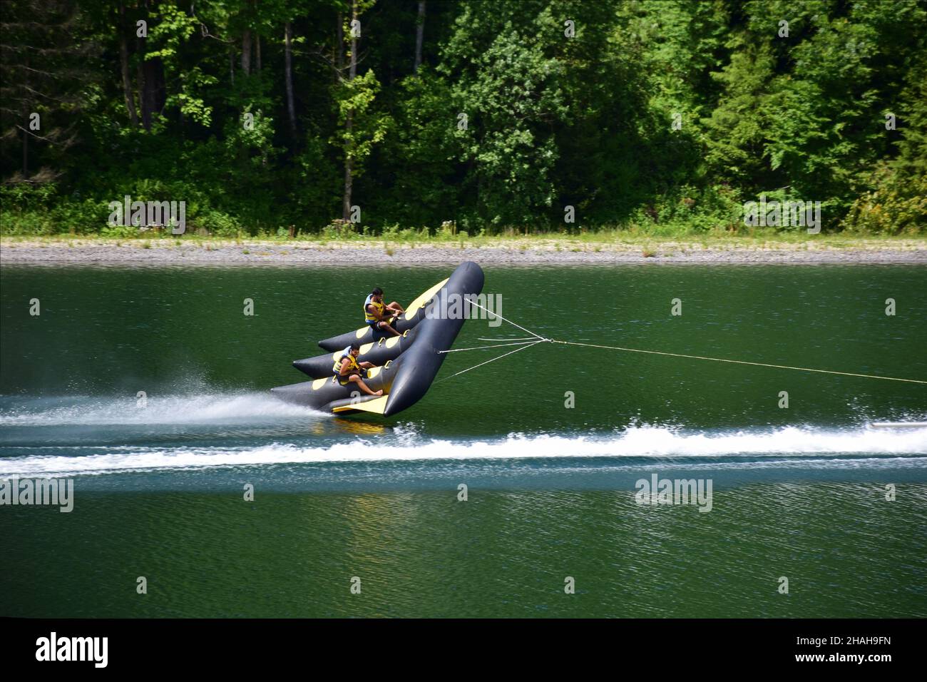 An inflatable sports raft with two men in life jackets quickly floats ...