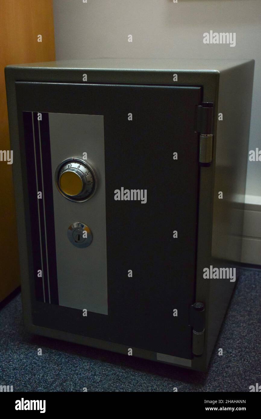 A small locked safe with a code and a lock is on the floor on the ...