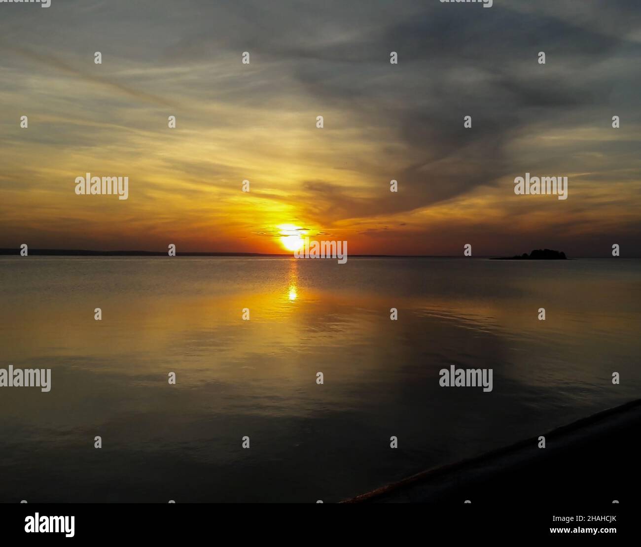 The sea surface of the water at sunset with a bright sun over the ...