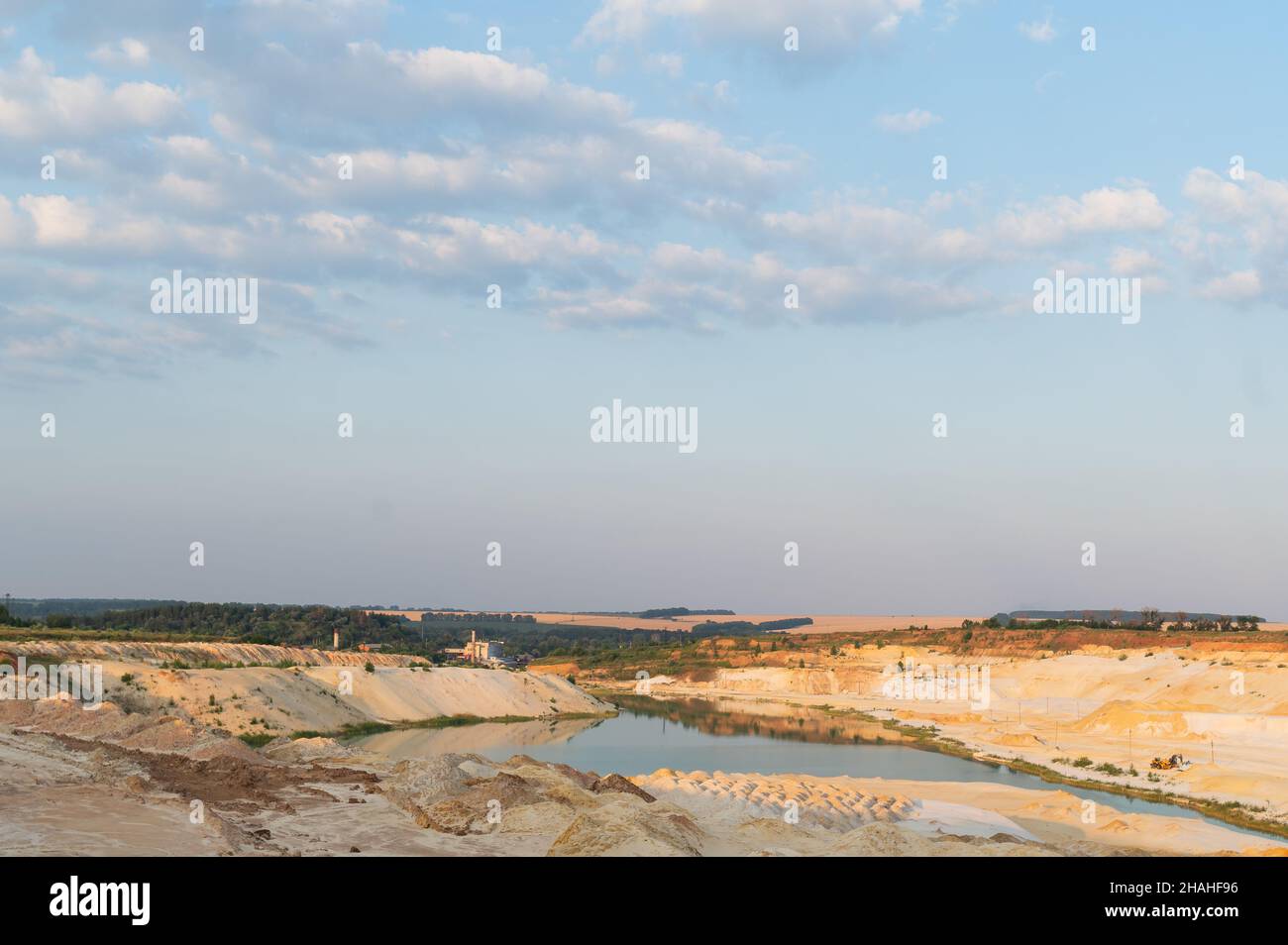Sand quarry. Turquoise lagoon and surface mine with exposed colored ...
