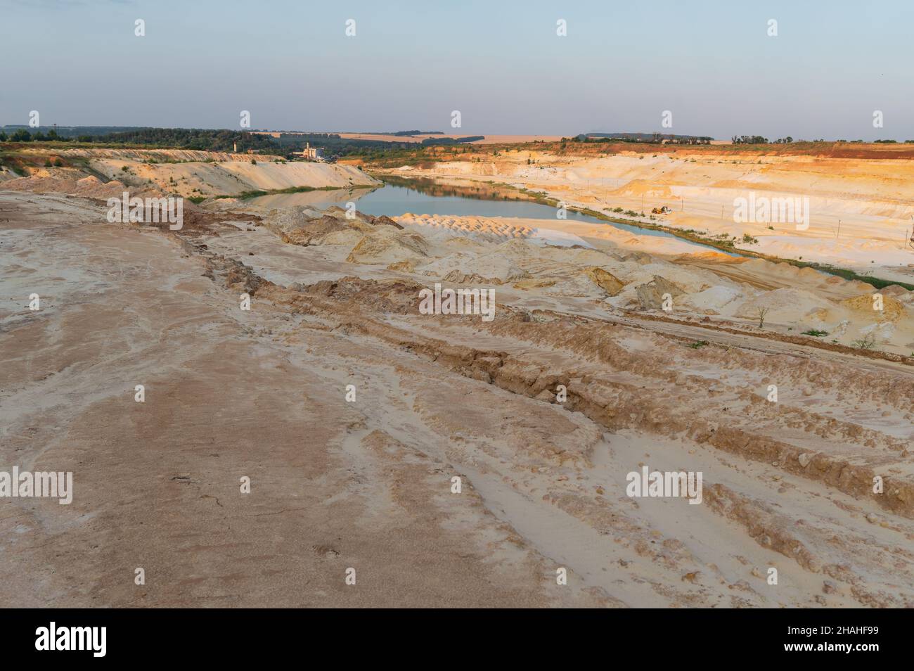 Sand quarry. Turquoise lagoon and surface mine with exposed colored ...