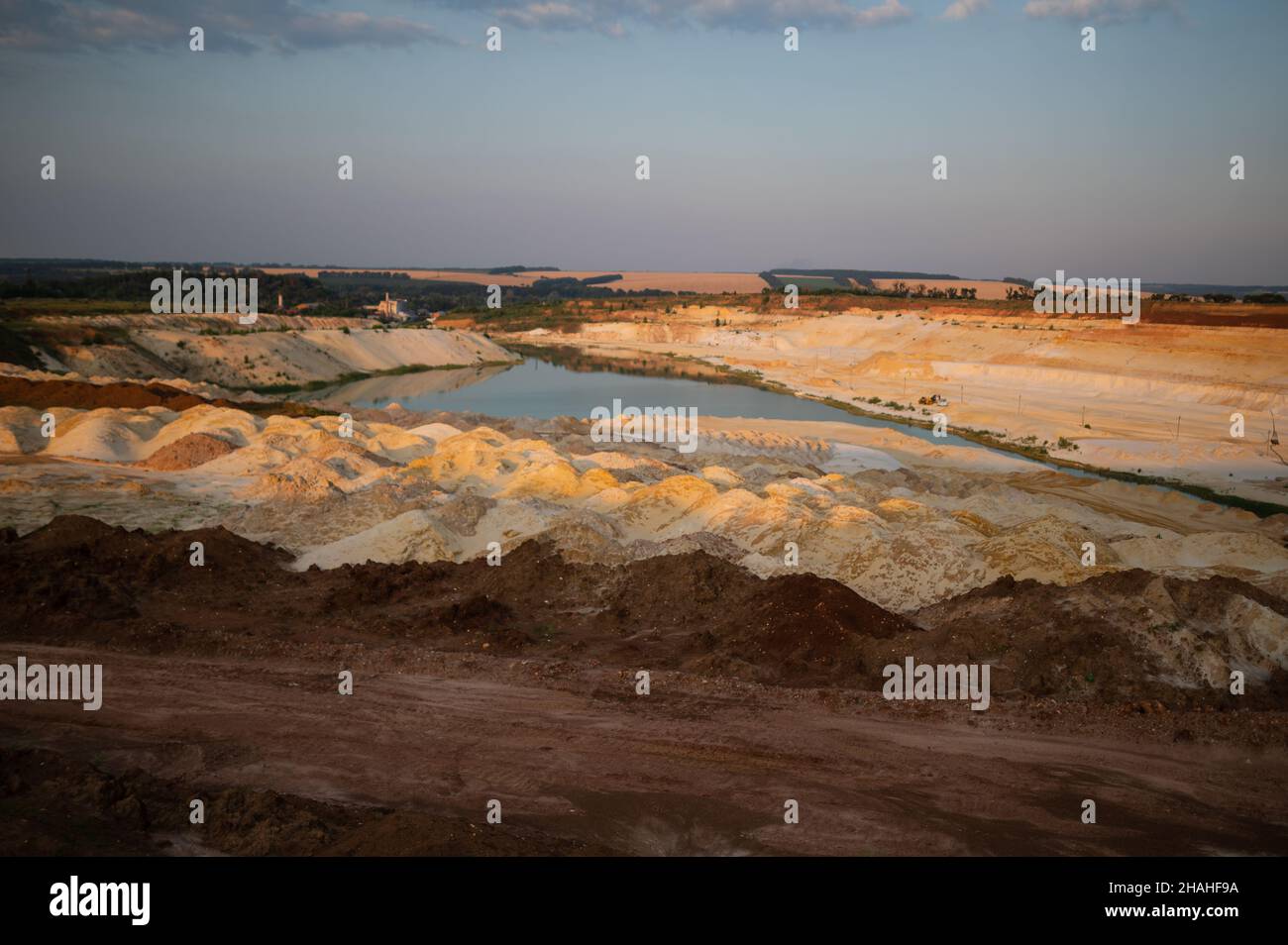 Sand quarry. Turquoise lagoon and surface mine with exposed colored ...