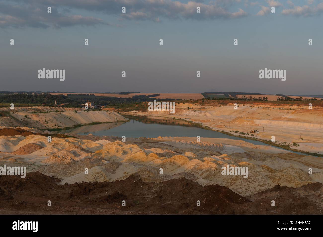 Sand quarry. Turquoise lagoon and surface mine with exposed colored ...