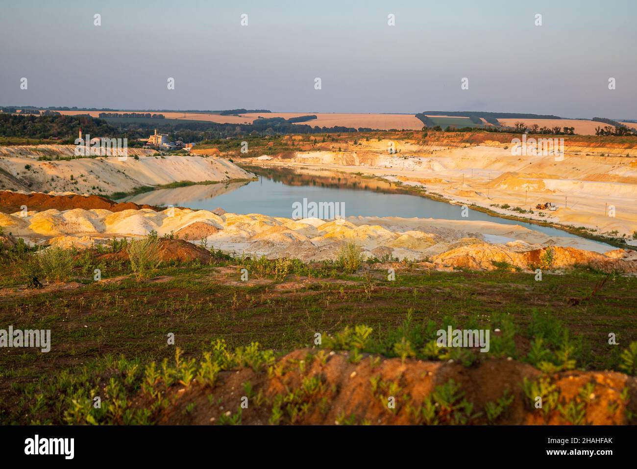 Sand quarry. Turquoise lagoon and surface mine with exposed colored ...