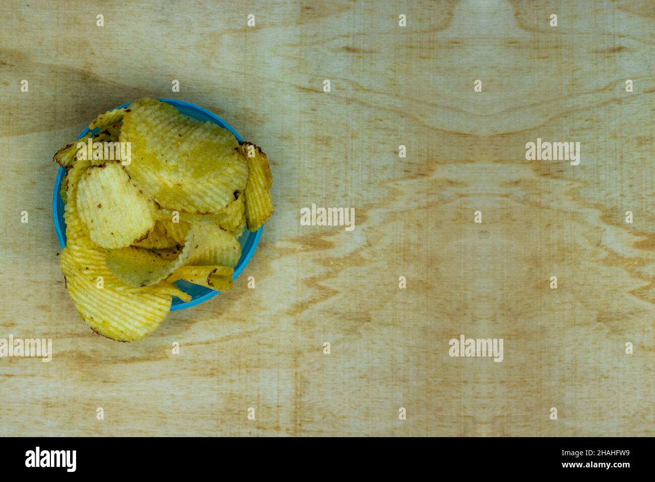 Salted Potato Wafers in Lite Blue Bowl on Wooden Table, Heap of Wafers ...