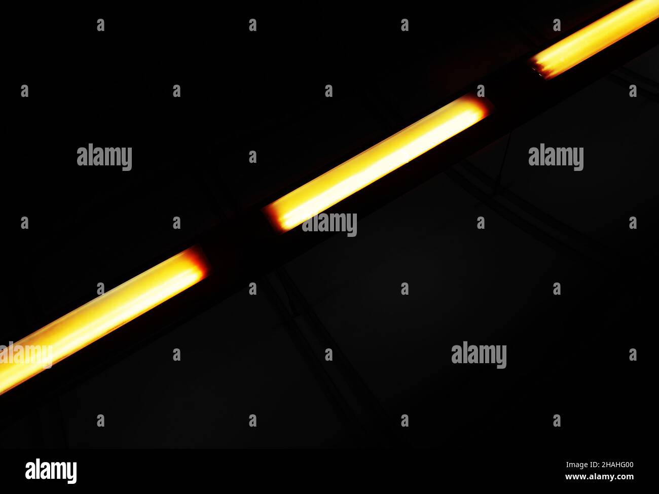 Diagonal yellow light lamps black backdrop Stock Photo - Alamy