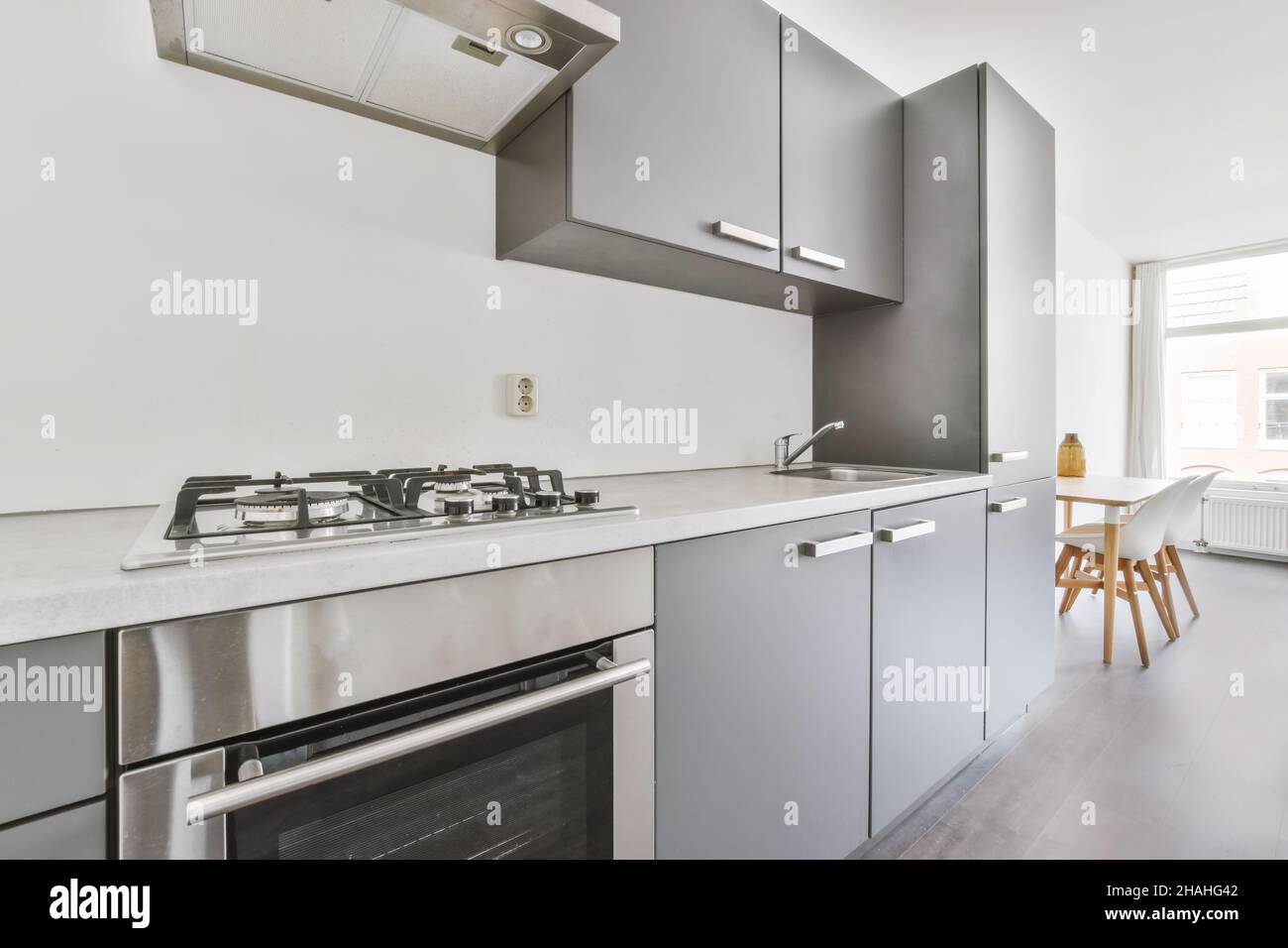 Elegant and cozy kitchen with gray kitchen unit Stock Photo - Alamy