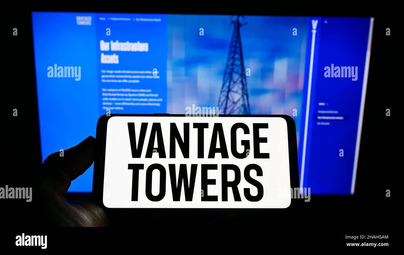 Person holding mobile phone with logo of German infrastructure company ...